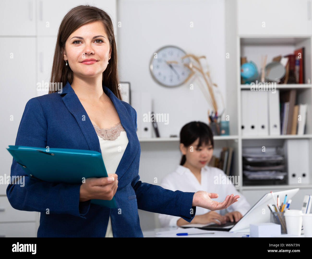 Elegant female assistant politely welcoming to modern company office ...