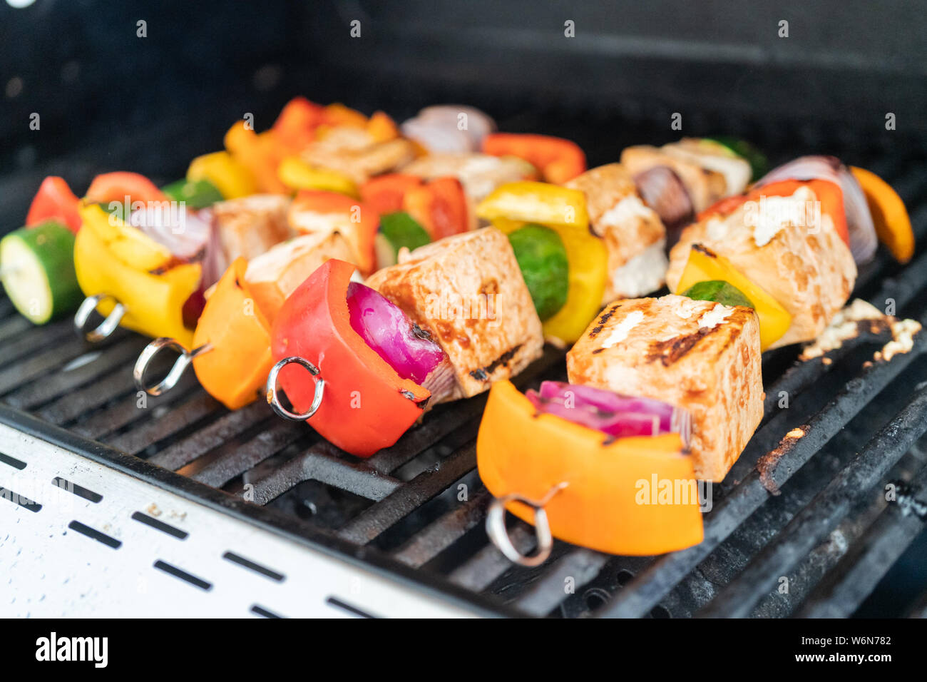 Grilling vegetarian tofu kebab with vegetables marinated in spicy sauce ...