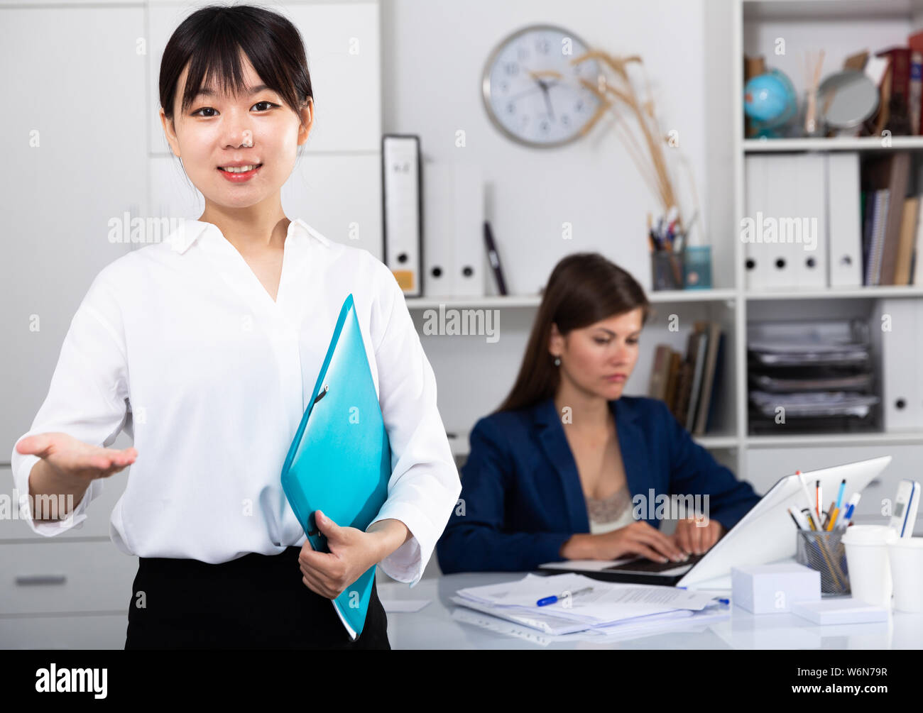 Positive asian female assistant politely welcoming to modern ...