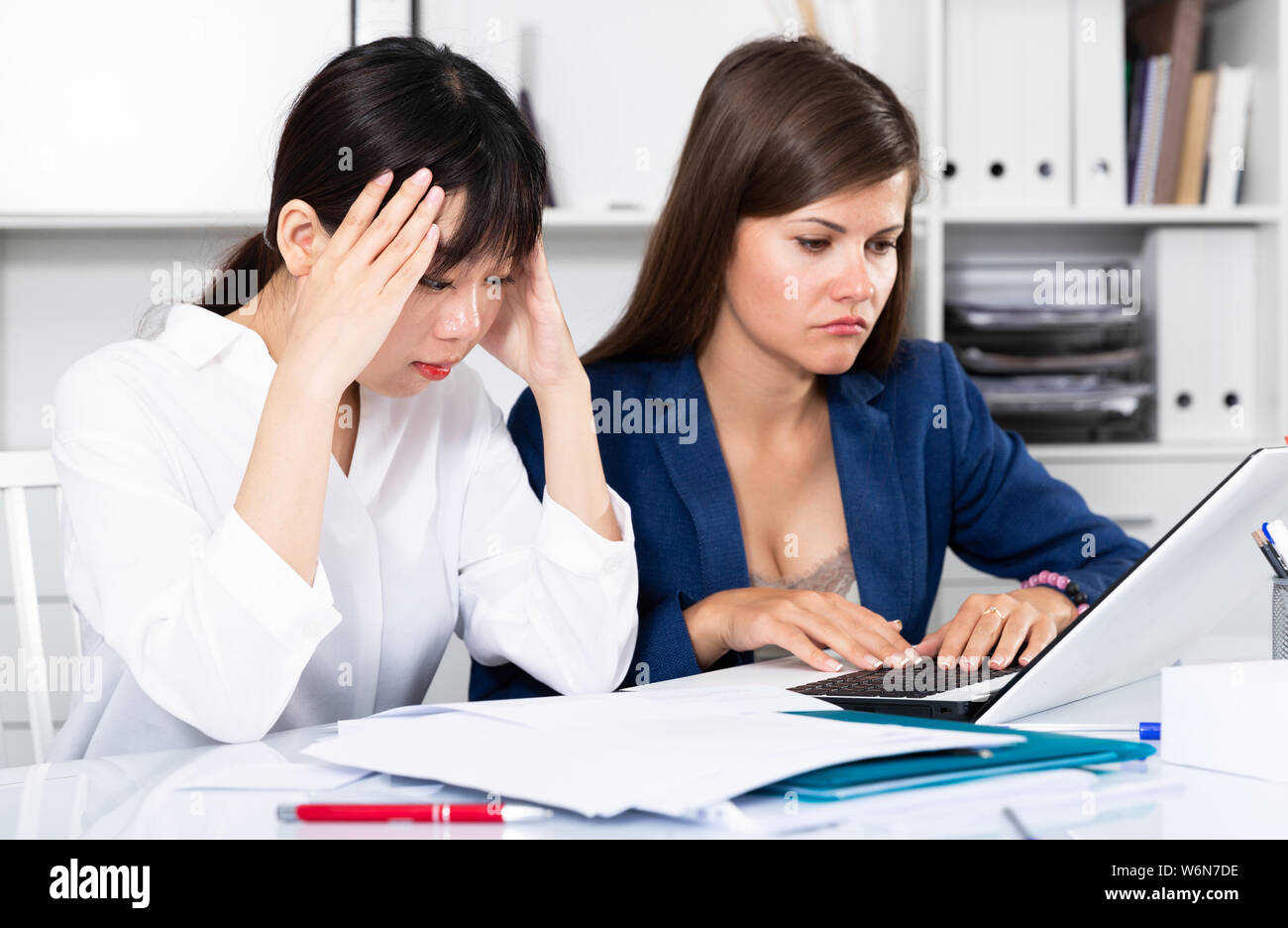 Women reading documents with upset faces at office Stock Photo - Alamy
