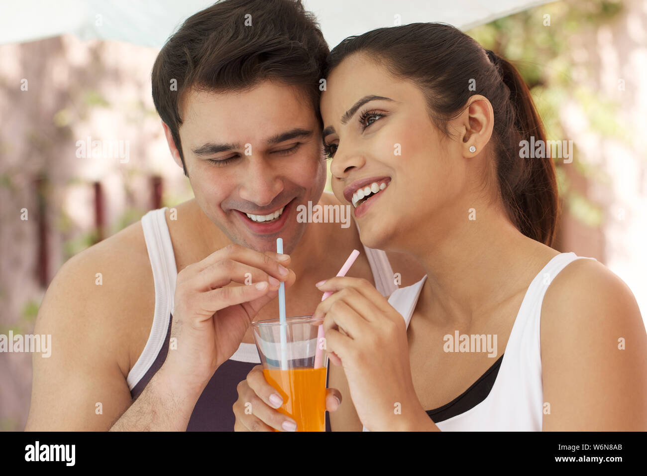Couple sharing a drink Stock Photo - Alamy