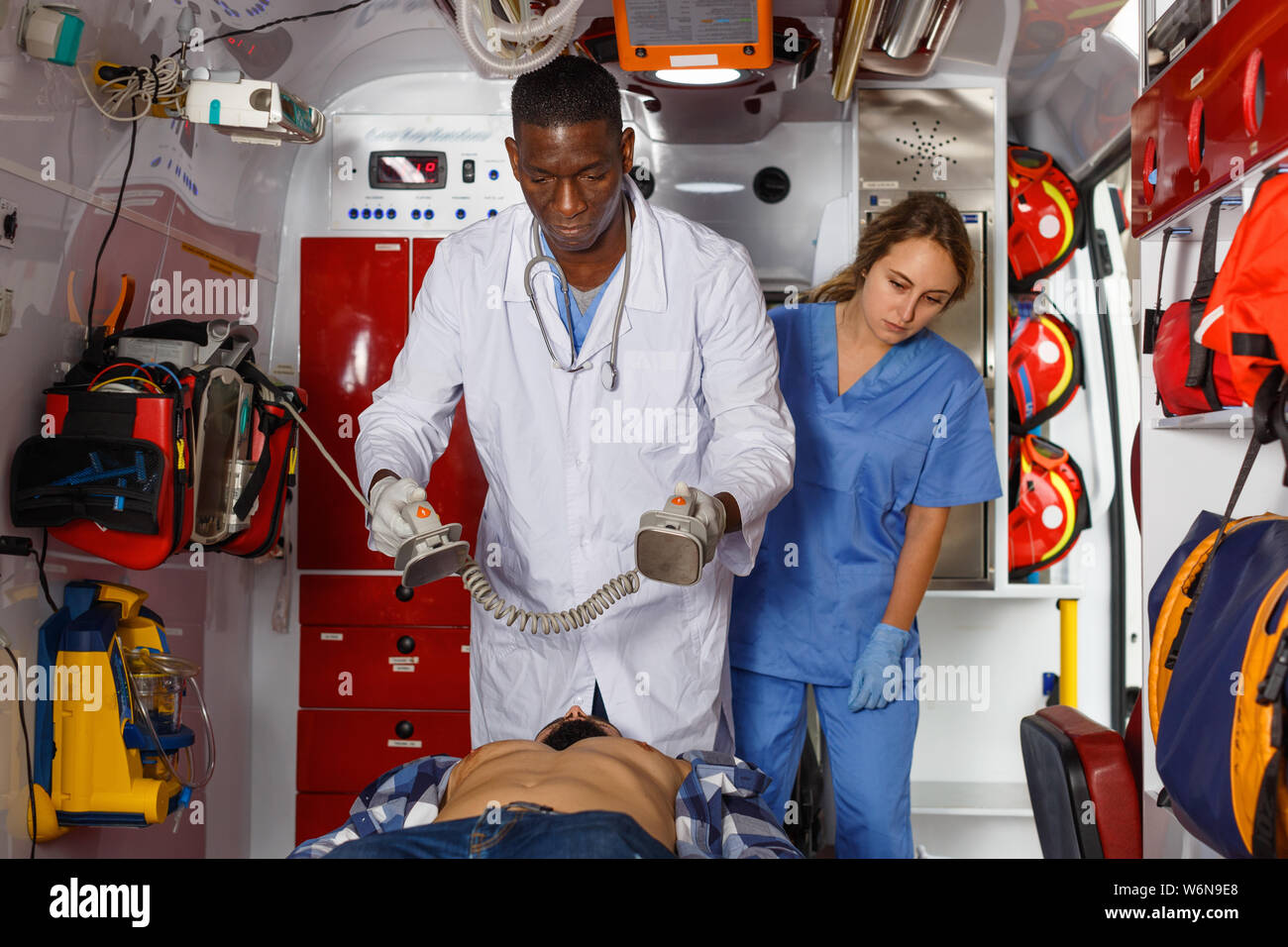 Diligent efficient serious emergency doctor resuscitating male patient ...