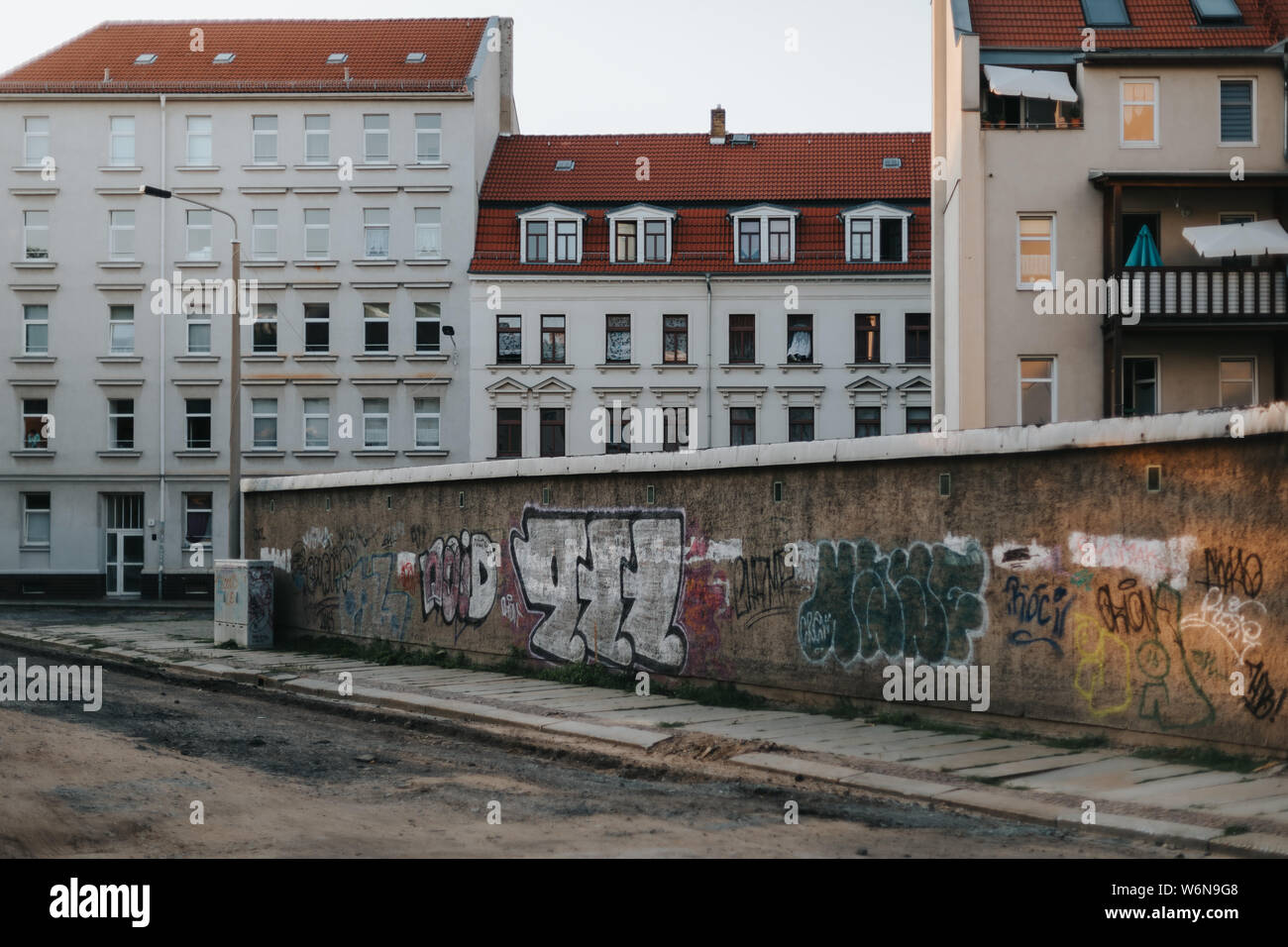 Empty street with graffiti covered wall in a working class neighborhood ...