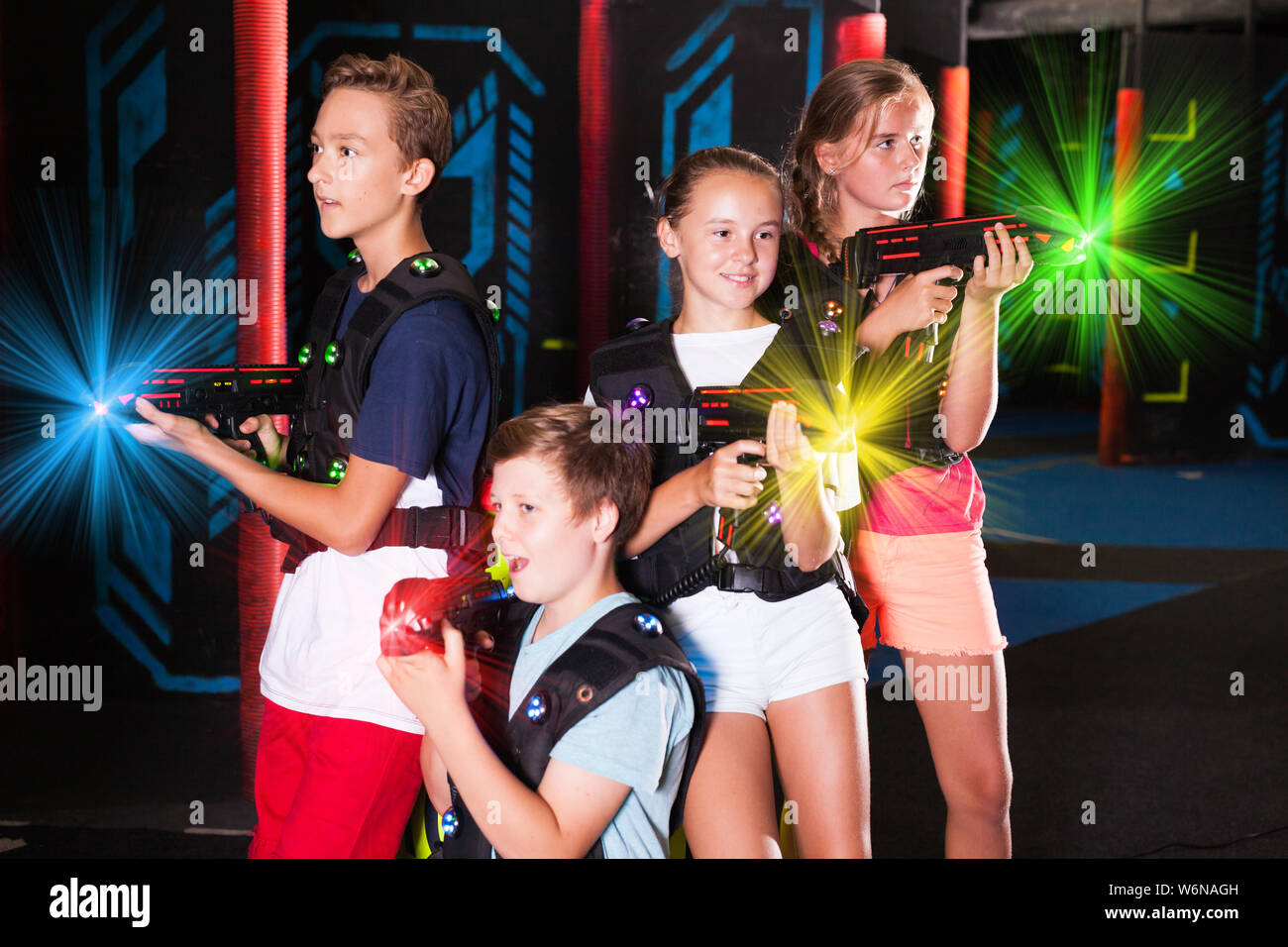 Portrait of excited teen kids with laser guns during lasertag game in ...