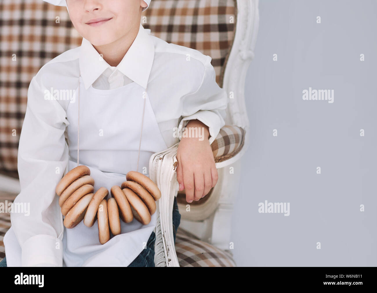 little boy in a chef uniform sitting on the kitchen couch. the concept ...