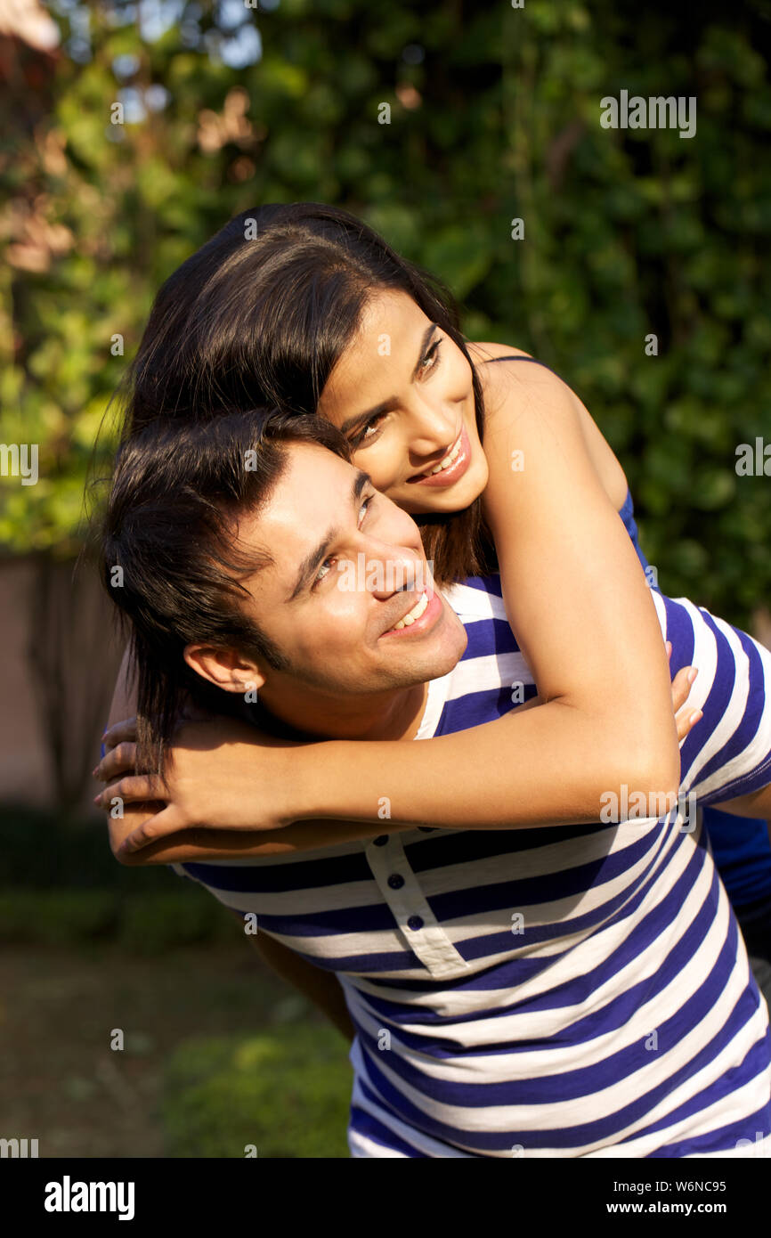 Woman riding piggyback on her husband and smiling Stock Photo - Alamy