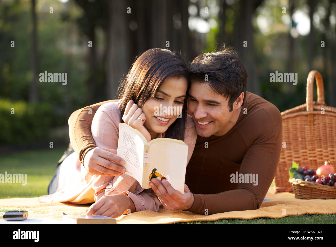 Couple Reading book at picnic Stock Photo - Alamy