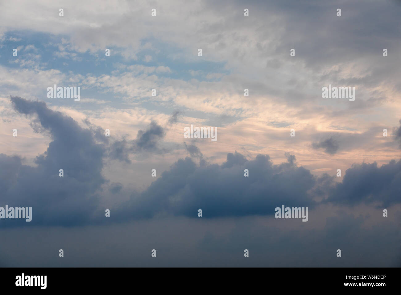 Layered sky, full of clouds of various sizes. dark in the lower part of ...