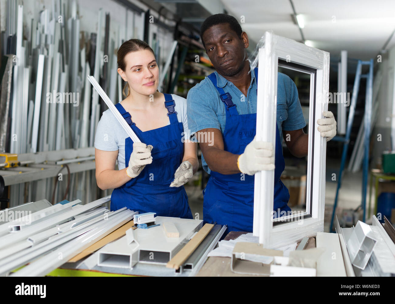 Two masters are working with window frame in the window workshop Stock ...