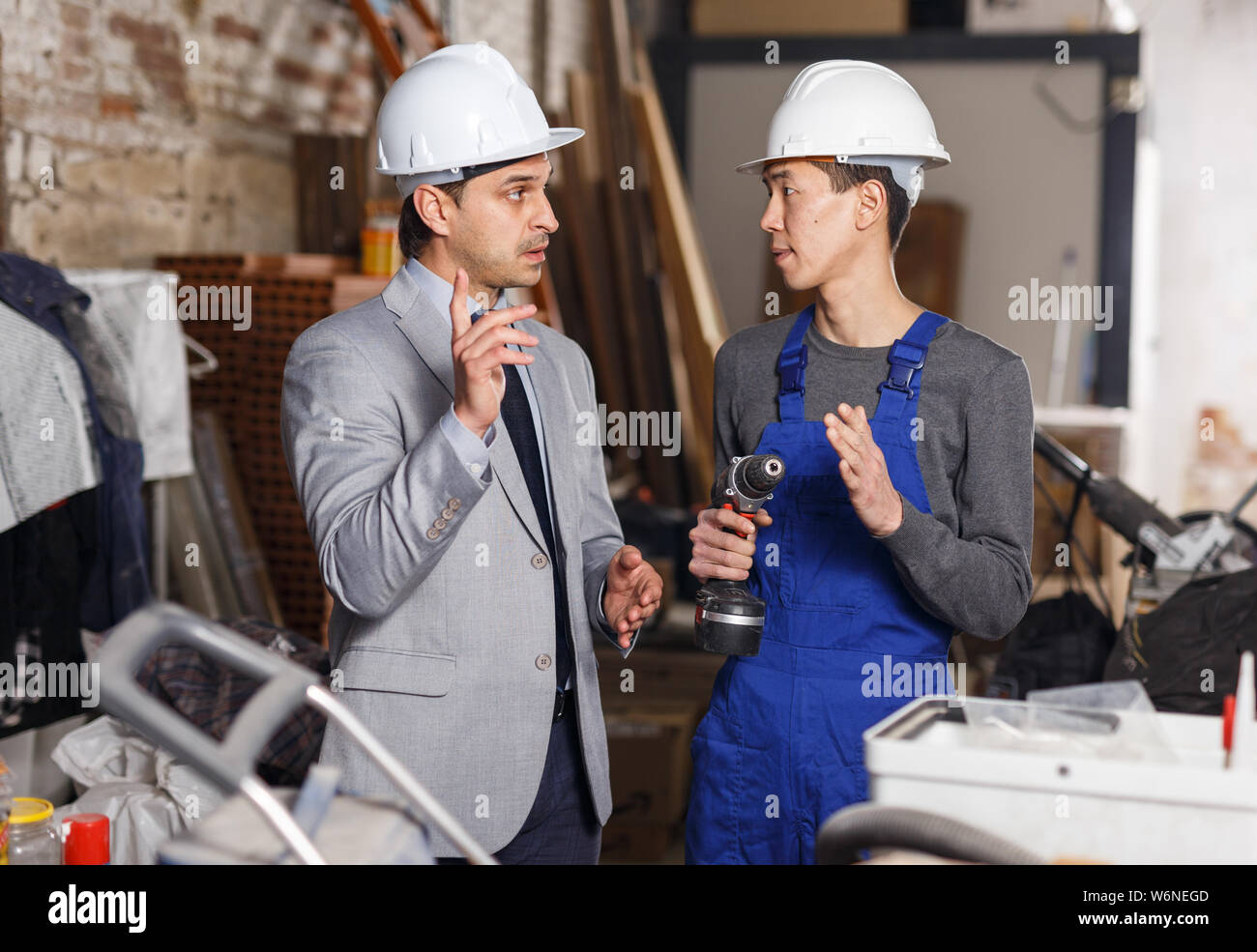 Male designer explaining professional builder details of plan at ...