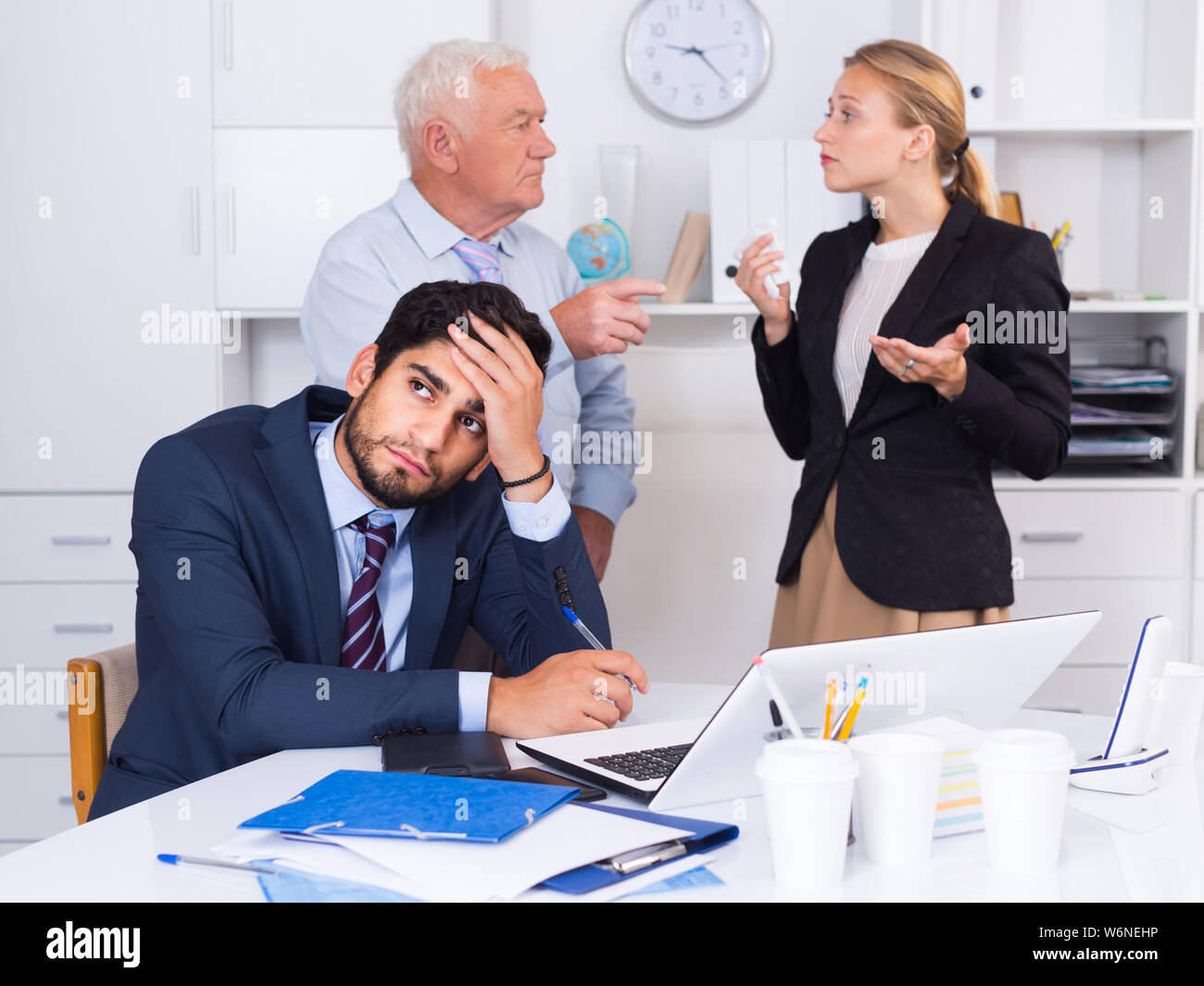Mature boss is chastising employees because of uncompleted work in the ...