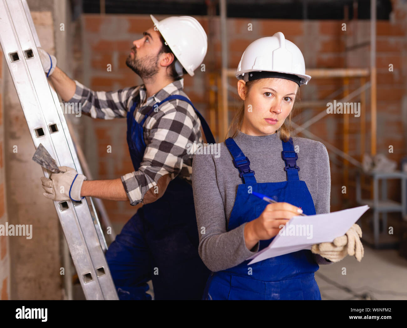Female foreman checking the work of the builders in house Stock Photo ...