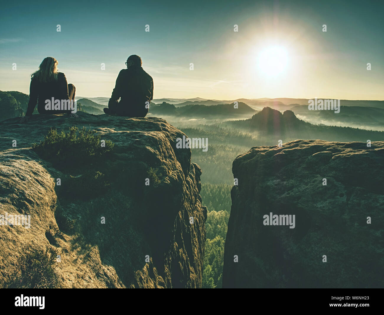 Two hikers taking pictures and talk on top of the mountain. Hikers ...
