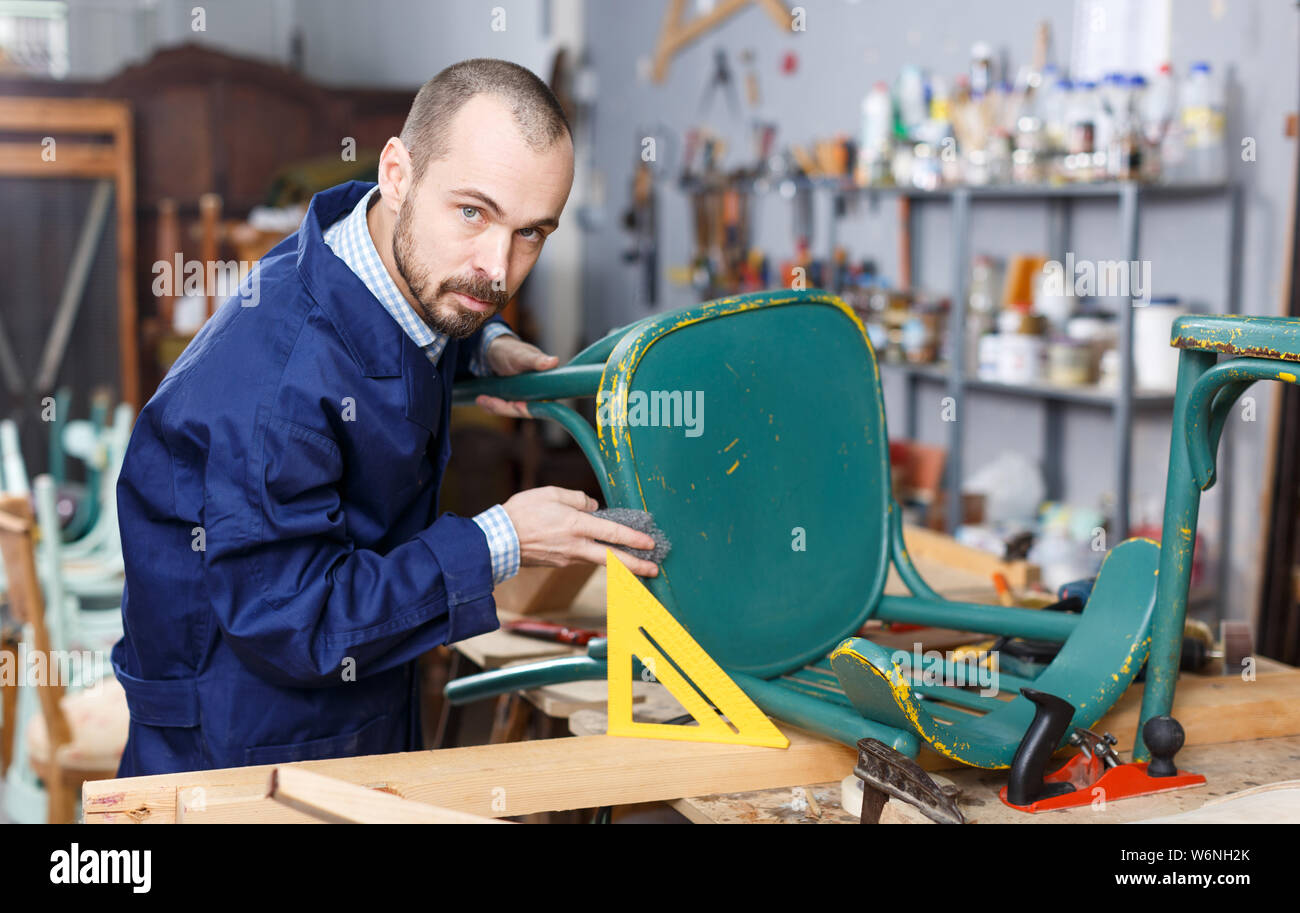 Furniture restorer renovation antique chair in his woodwork studio ...