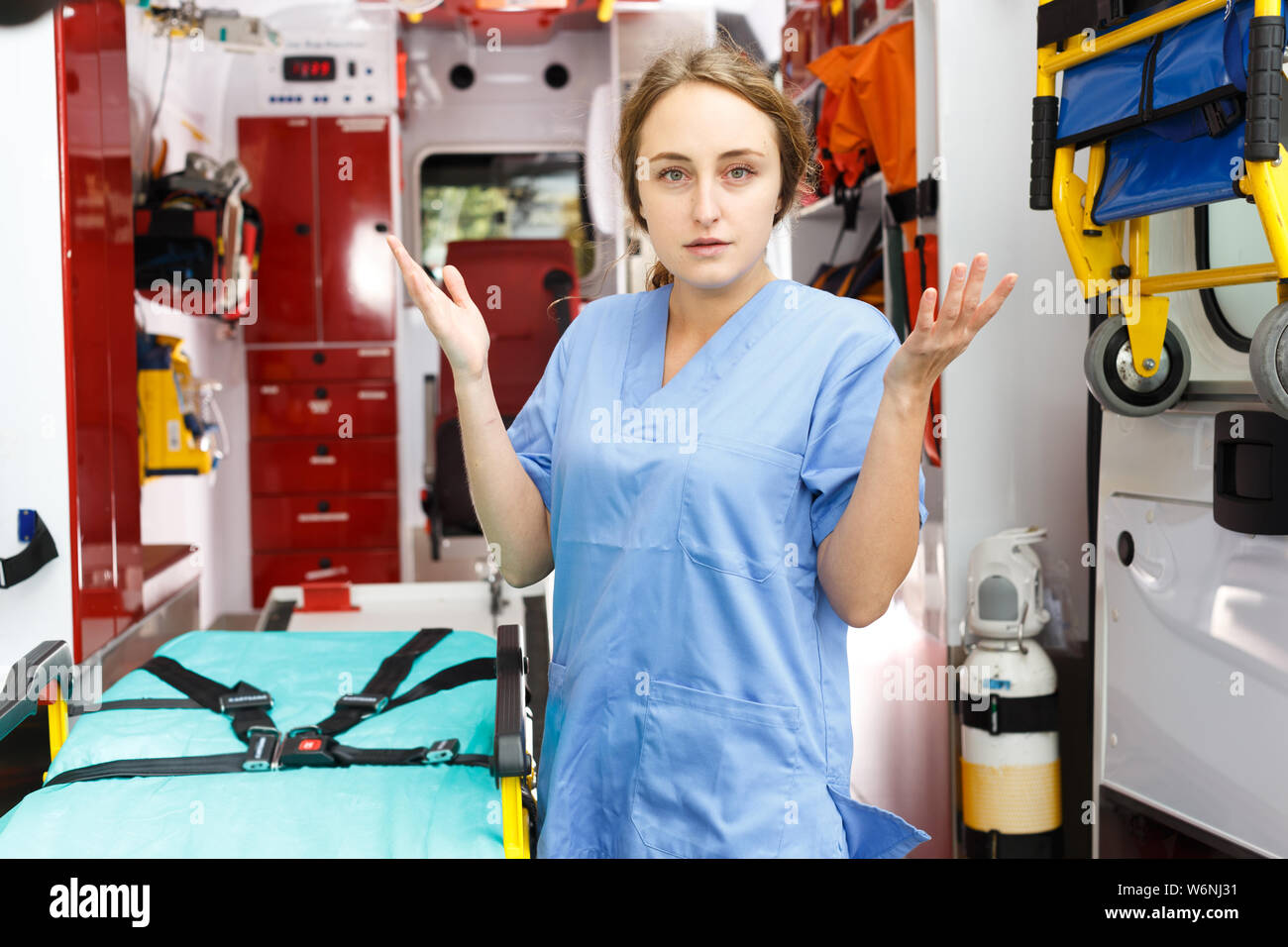 Portrait of female emergency doctor throwing up her hands in ambulance ...