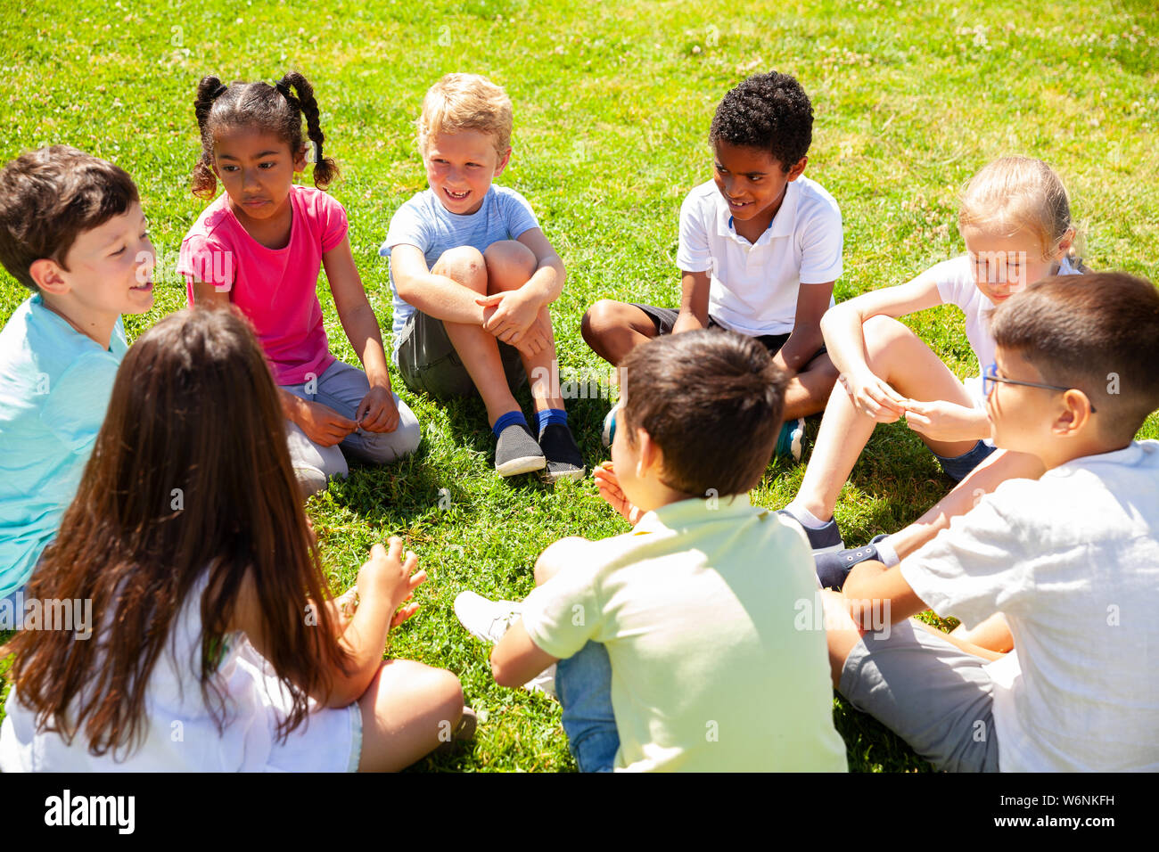 Group of elementary school children chatting on the green lawn Stock ...