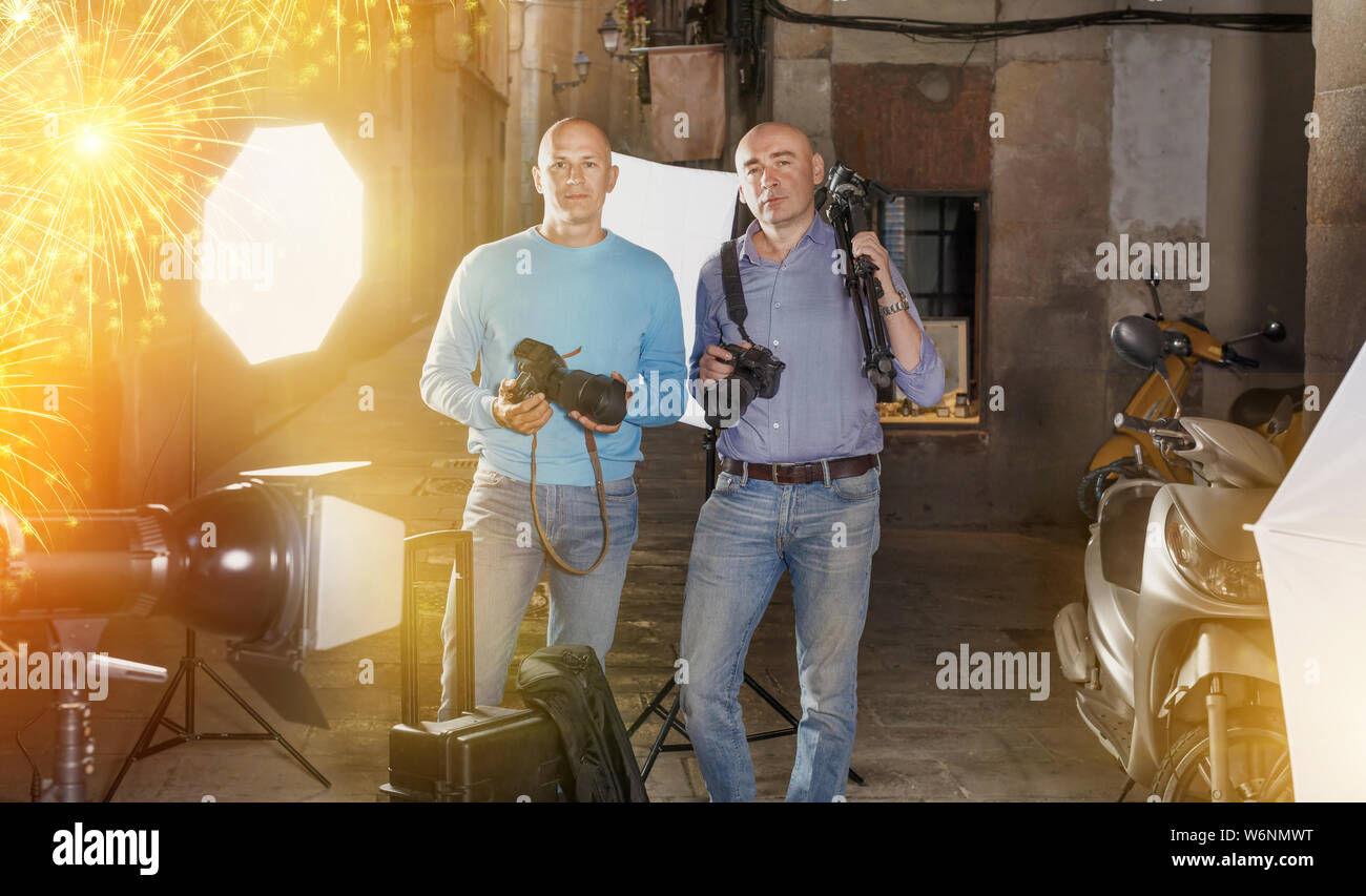 Portrait of two successful photographers with their cameras during ...