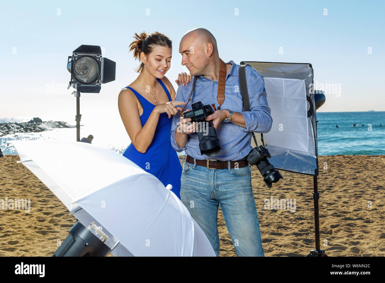 Photographer and cheerful positive smiling model discussing picture on ...