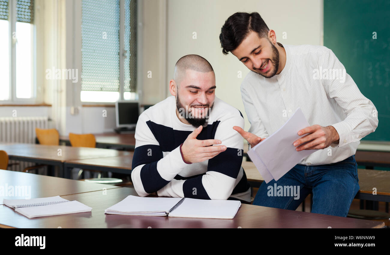 Two young handsome students having discussion about their university ...