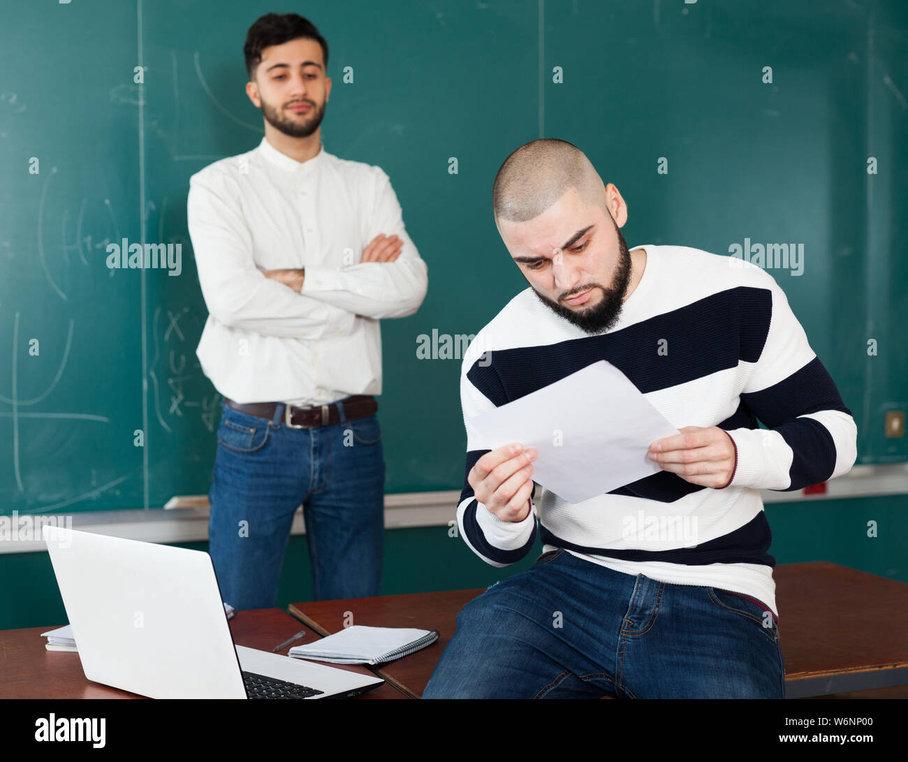 Two male university students preparing for exams together at classroom ...