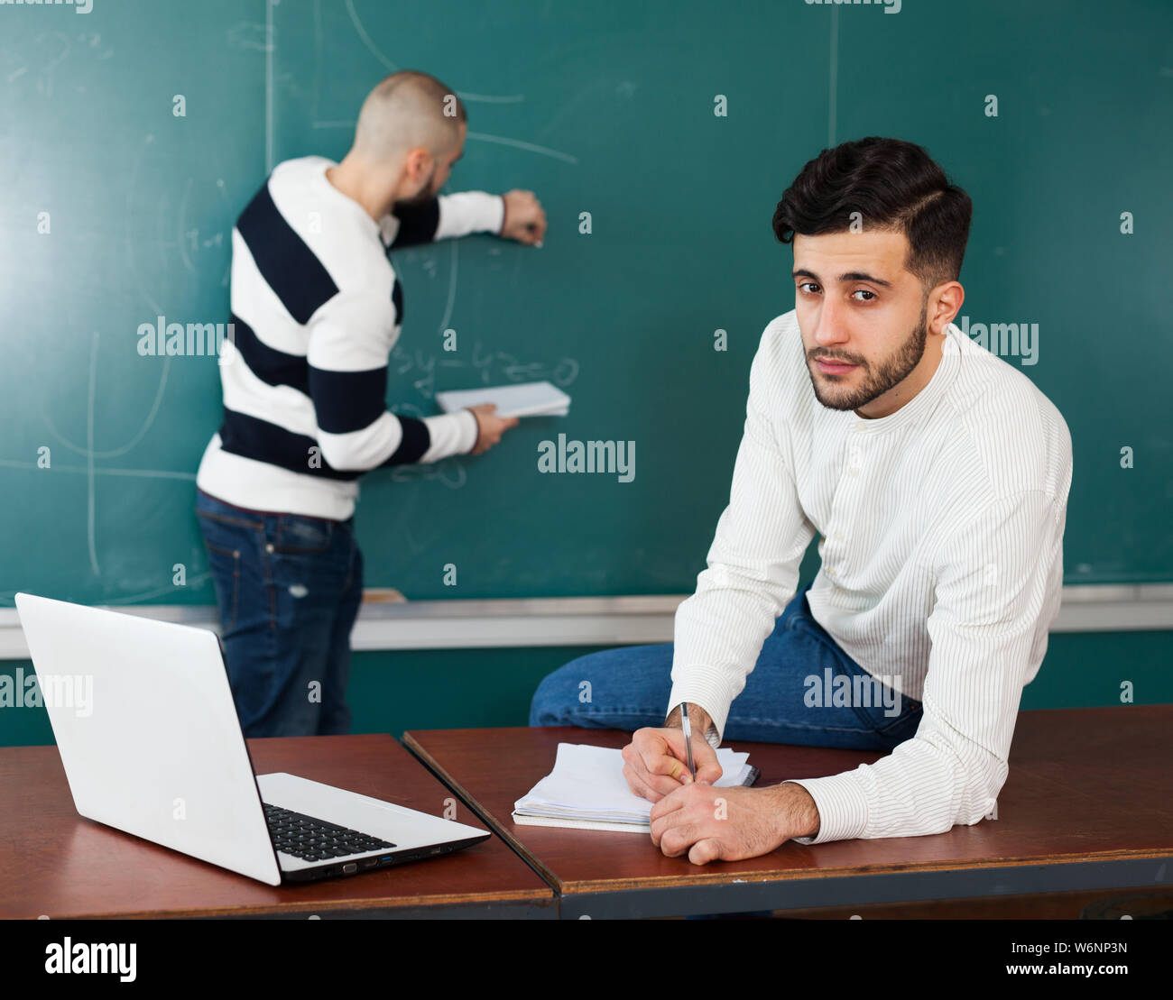 Two male university students preparing for exams together at classroom ...
