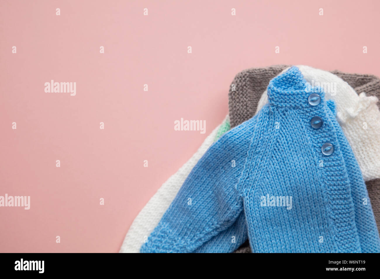 Cute knitted baby clothes layout on a pastel pink background Stock ...