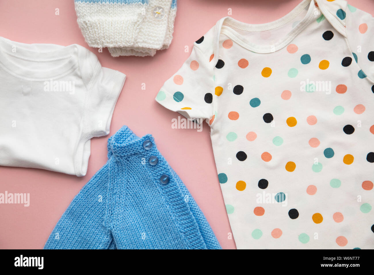 Cute baby clothes layout on a pastel pink background Stock Photo - Alamy