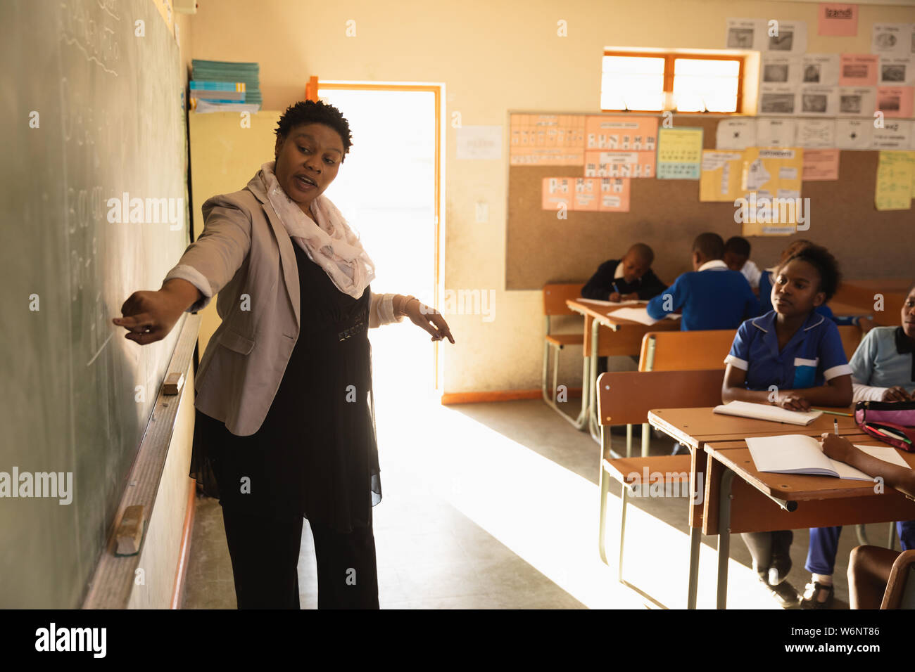 Female teacher at the blackboard in front of class Stock Photo - Alamy