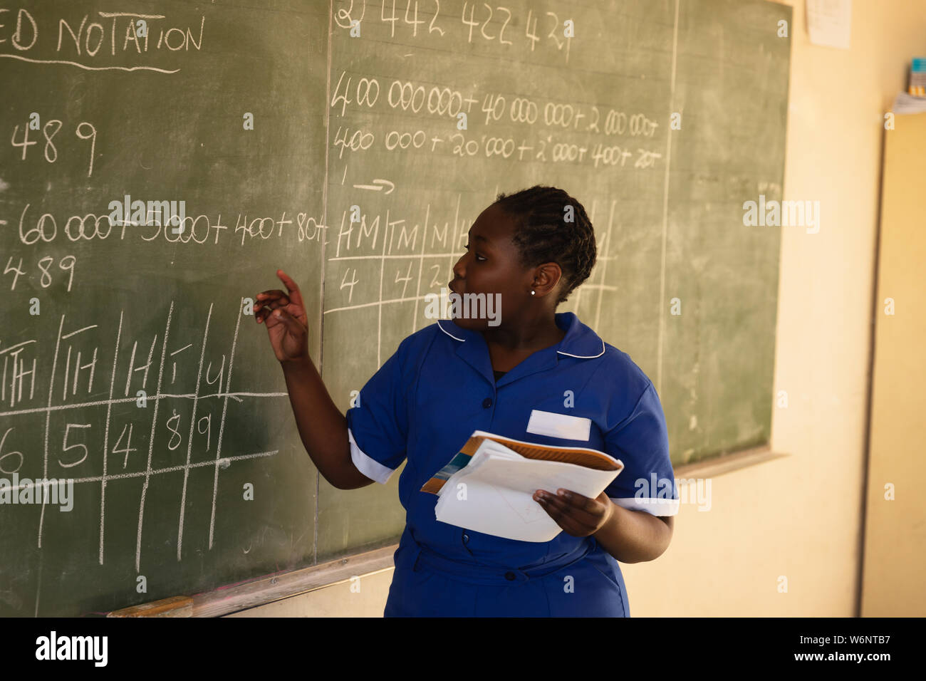 Young schoolgirl writing on the blackboard in class Stock Photo - Alamy