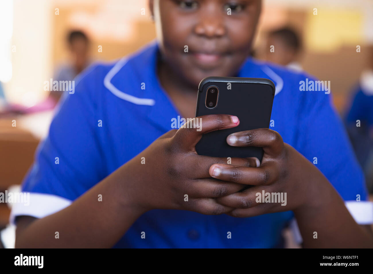 Schoolgirl using smartphone in classroom at a township school Stock ...
