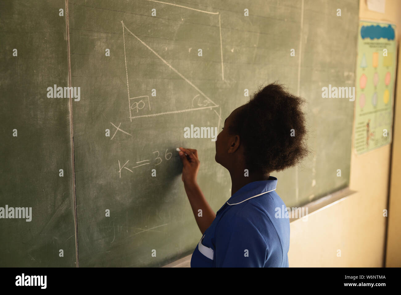 Young schoolgirl writing on the blackboard in class Stock Photo - Alamy