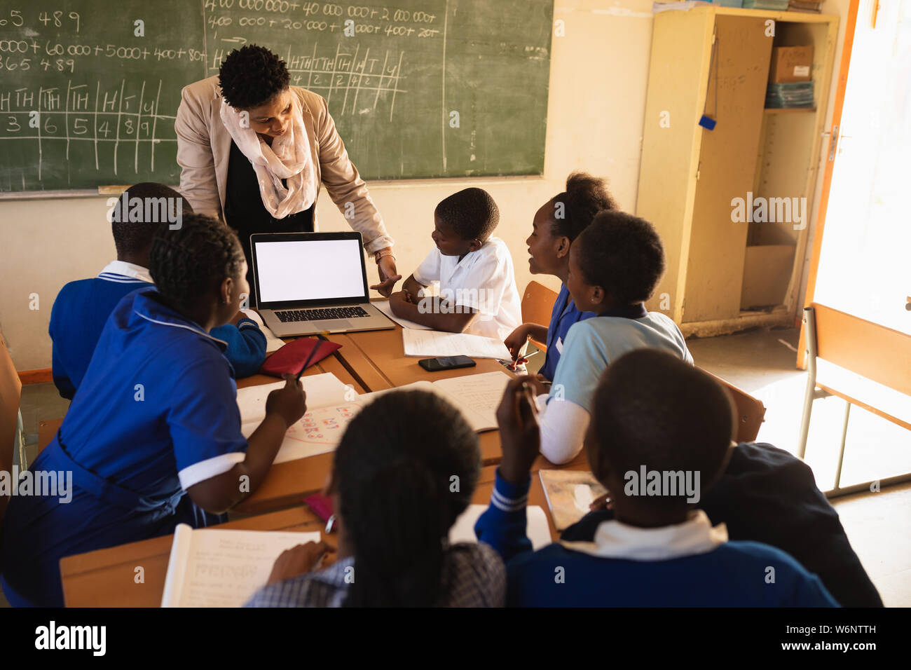 Teacher and pupils with laptop in class Stock Photo - Alamy