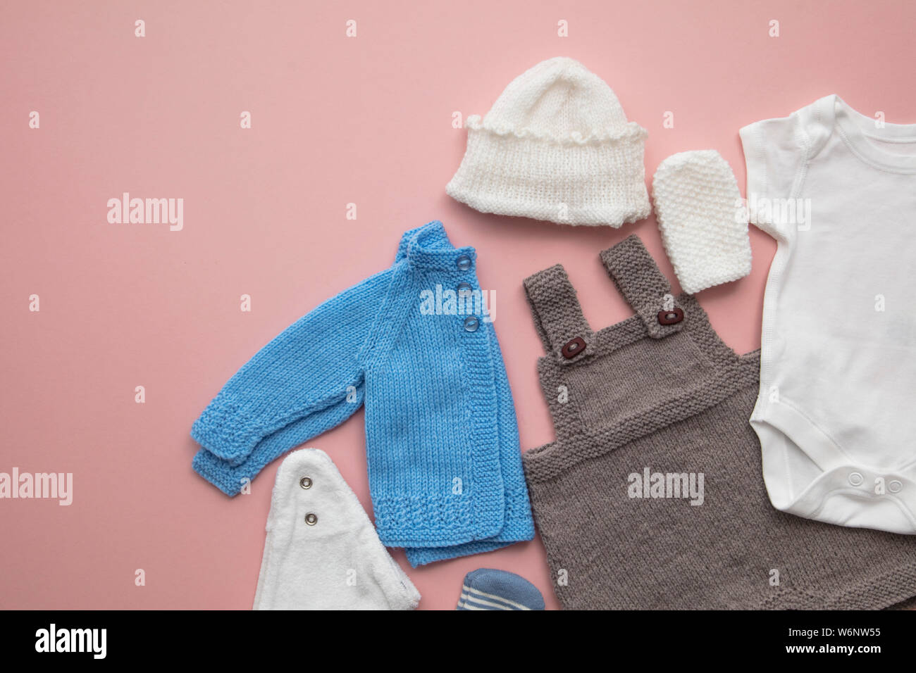 Cute baby clothes layout on a pastel pink background Stock Photo - Alamy