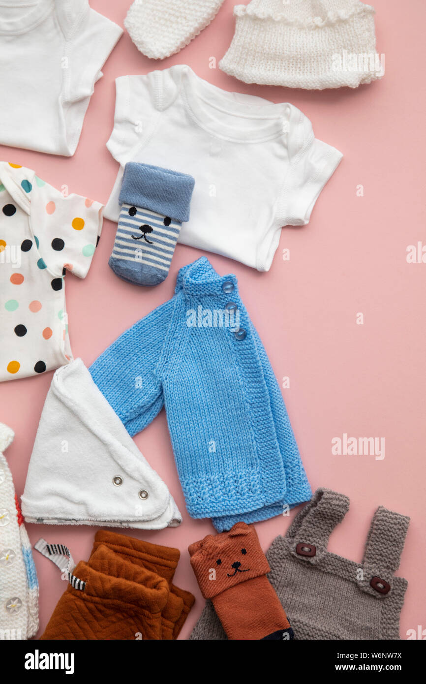 Cute baby clothes layout on a pastel pink background Stock Photo - Alamy