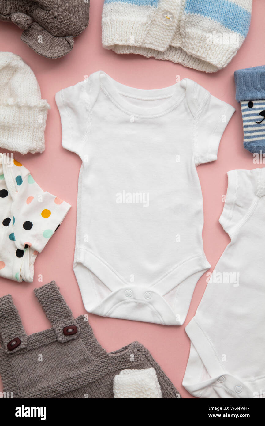 Newborn child clothing layout on a pastel pink background Stock Photo ...