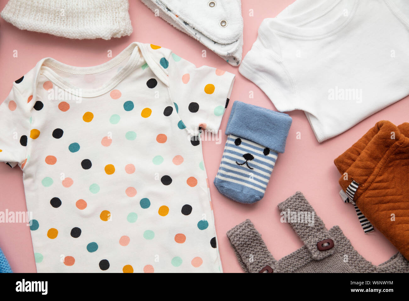 Cute baby clothes layout on a pastel pink background Stock Photo - Alamy