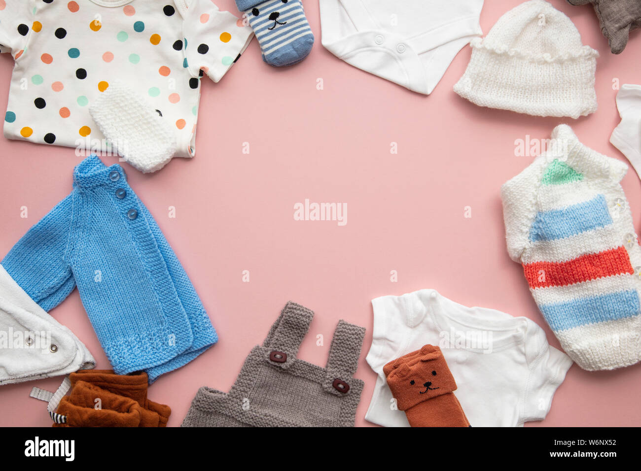 Cute baby clothes layout on a pastel pink background Stock Photo - Alamy