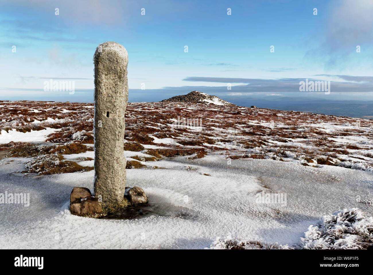 View of a pillar stone on Slievenamon Mountain summit with a big cairn ...