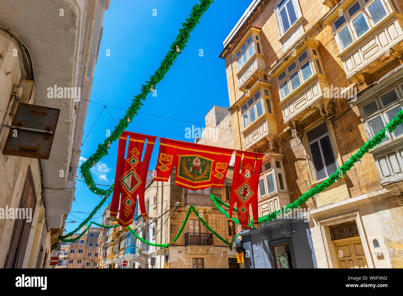 Typical narrow maltese streets with colorful traditional windows and ...