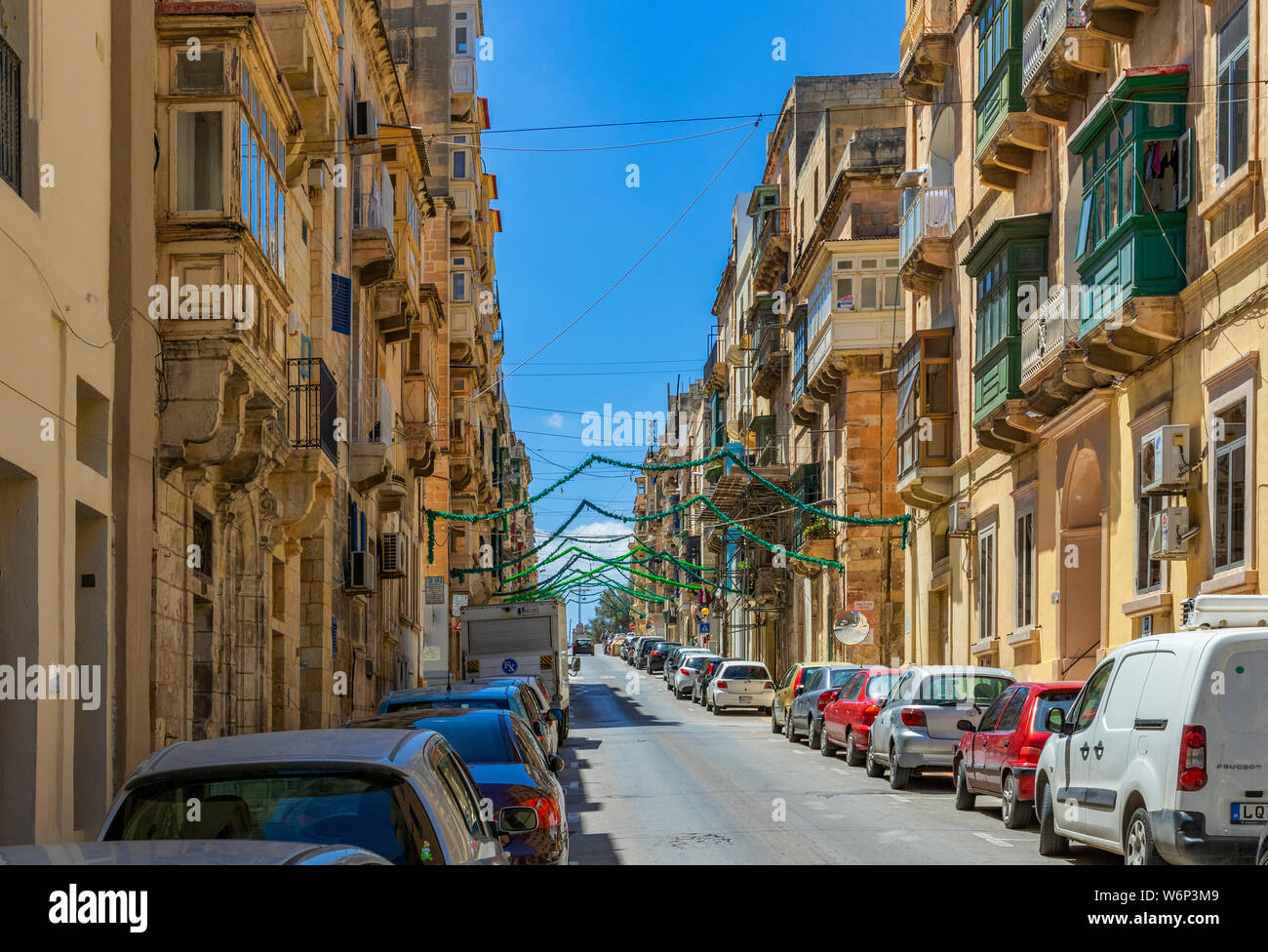 Typical narrow maltese streets with colorful traditional windows and ...