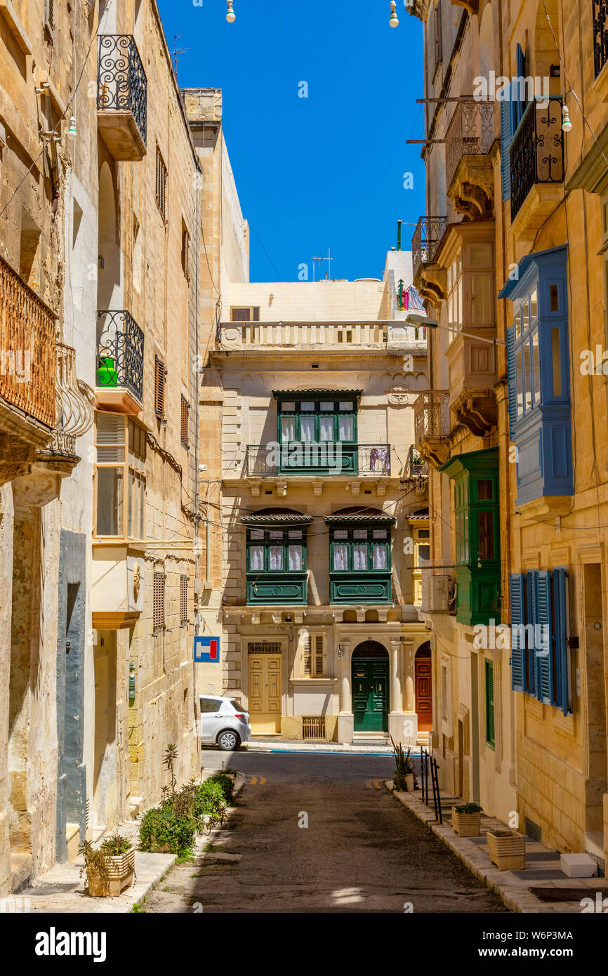 Typical narrow maltese streets with colorful traditional windows and ...