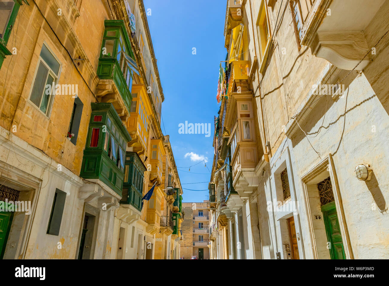 Typical narrow maltese streets with colorful traditional windows and ...