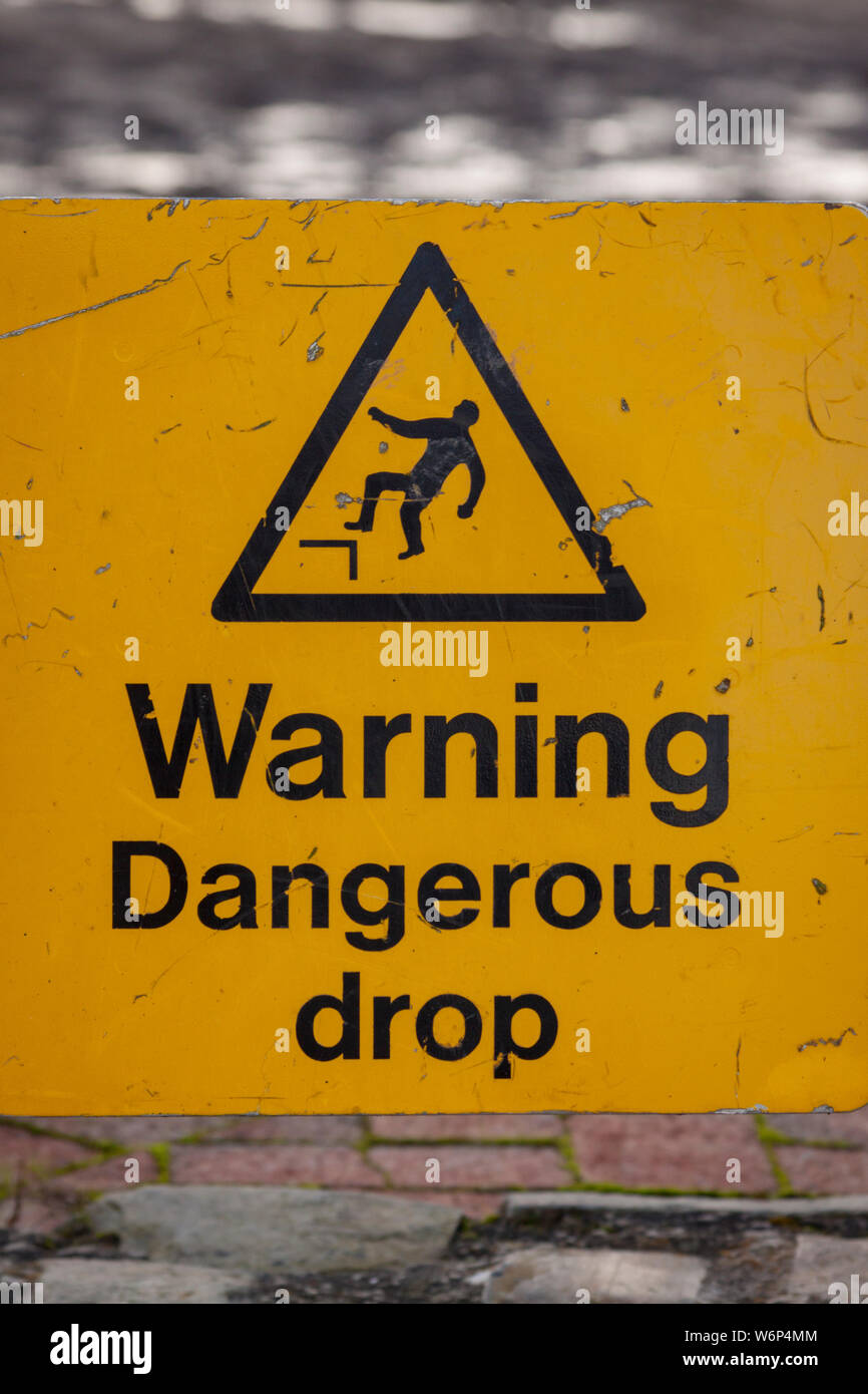 close up view of yellow warning sign for dangerous drop Stock Photo - Alamy