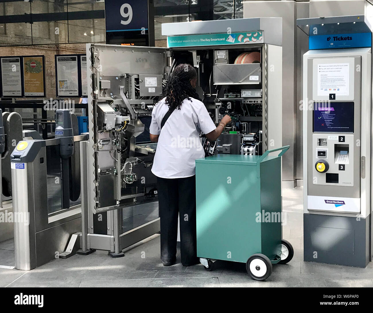 General view of a station worker replenishing a ticket machine at Kings ...