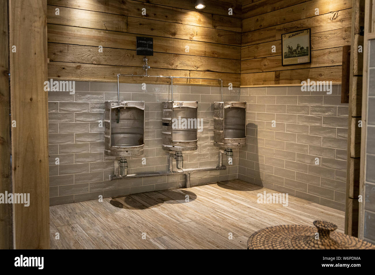 Stainless steel beer barrels repurposed as urinals in a gents toilet ...