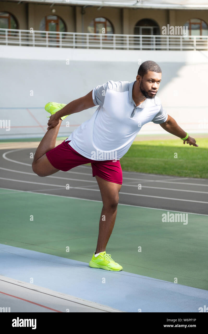Calm athletic young man standing on one leg Stock Photo - Alamy