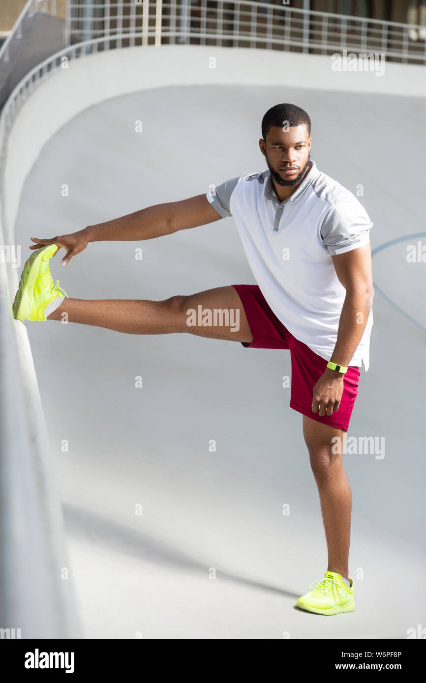 Handsome pensive sportive young man doing leg workout Stock Photo - Alamy