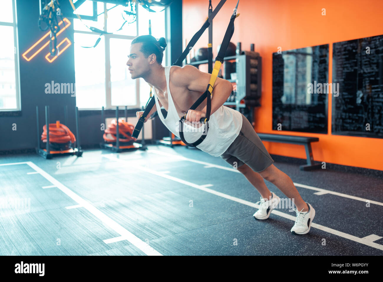 Smart handsome man focusing on his trx workout Stock Photo - Alamy