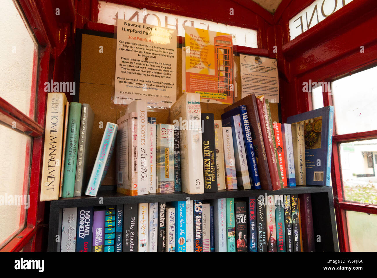 Books on shelves forming a little local library in an old red phone box ...