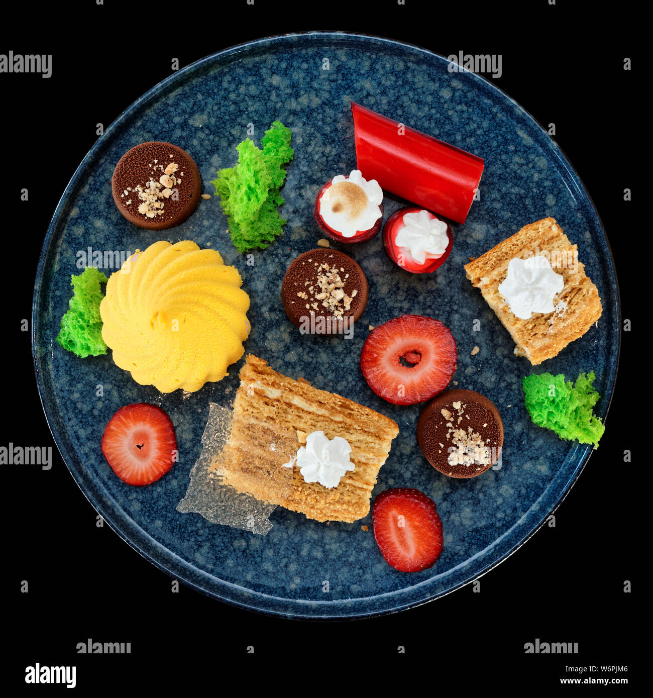 Set of various desserts in stone plate isolated on black background ...